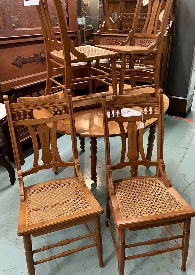 Cane-seat chairs with turned spindles and carved details, built by hands that clearly had no interest in cutting corners.