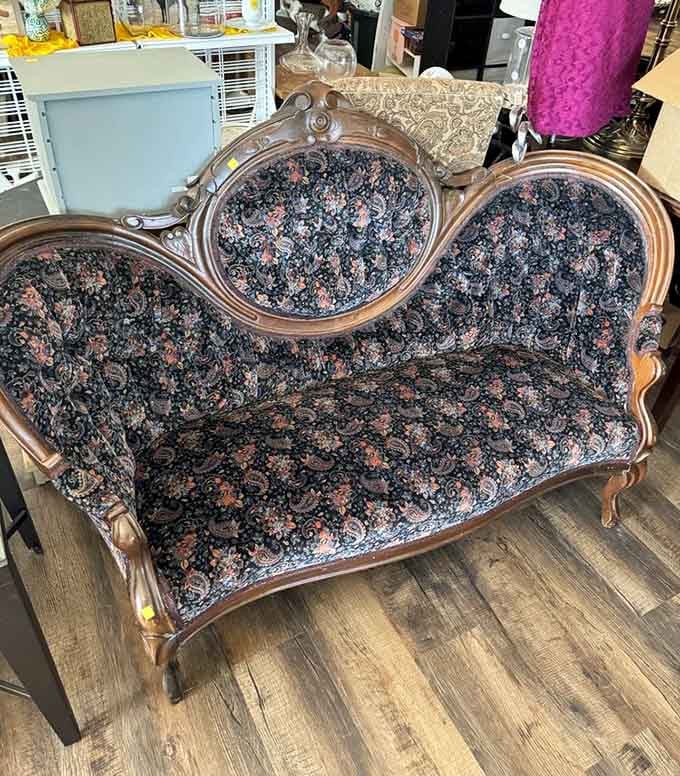 A Victorian parlor settee with carved wood and dark paisley fabric. Your great-grandmother would approve wholeheartedly.