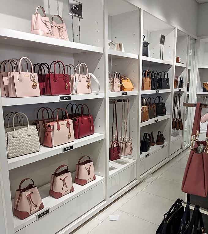 Designer bags lined up like soldiers, ready to march home with you at outlet prices.
