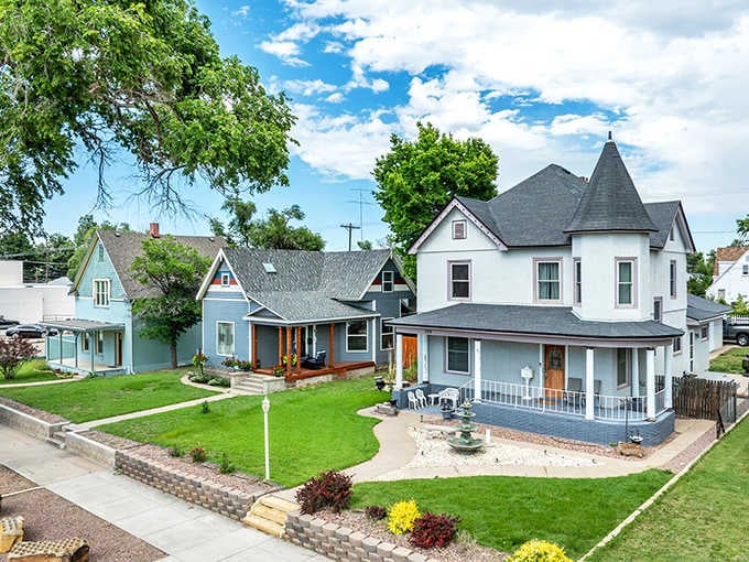 Victorian homes with actual front porches remind you when neighborhoods were built for conversation, not just curb appeal.