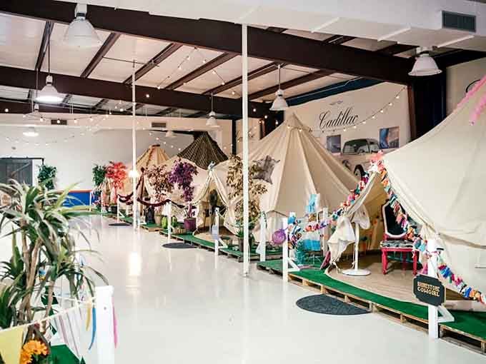 Canvas tents lined up indoors like a glamping village that never has to check the weather forecast.