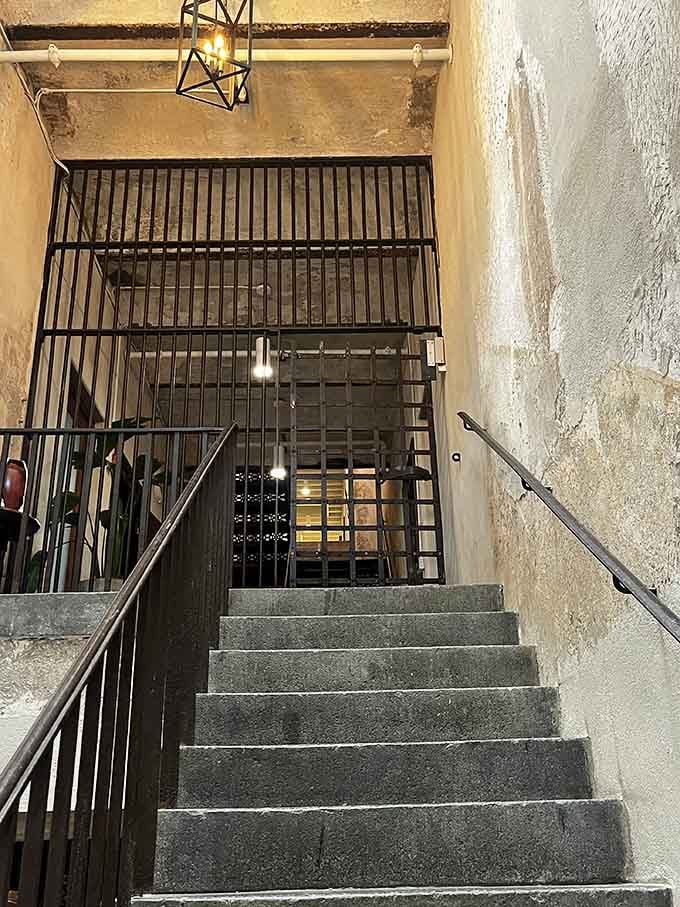 Heavy bars, dim light, stone steps going nowhere good. This entrance means serious business.