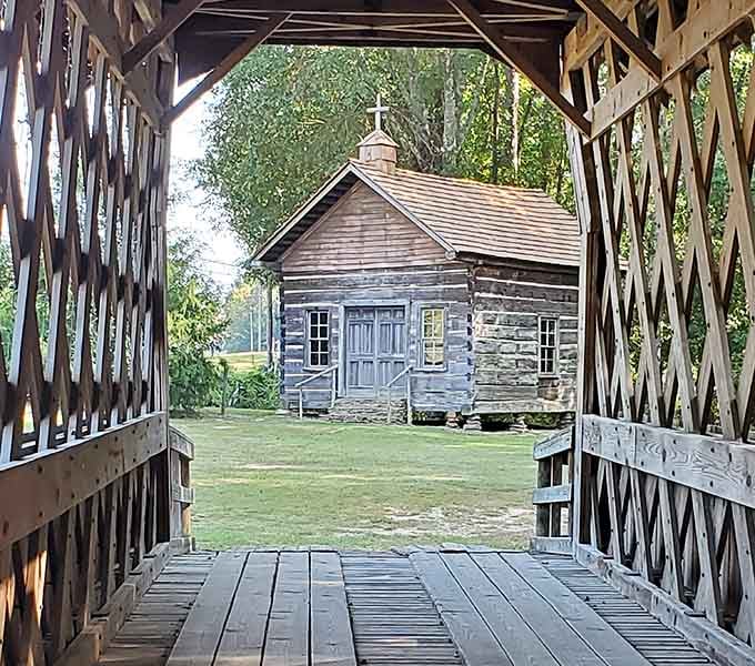The log church frames perfectly through the bridge, creating a postcard moment your camera roll desperately needs.