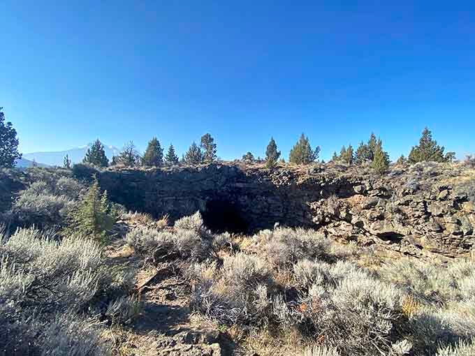 The cave opening emerges from the sagebrush landscape like a portal that's been waiting millennia for you.