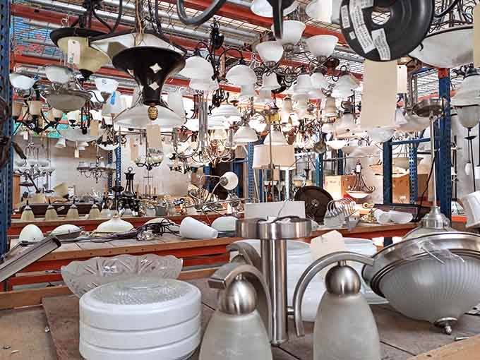 Dozens of vintage light fixtures hanging overhead, proof that someone else's old chandelier is your next great design moment.