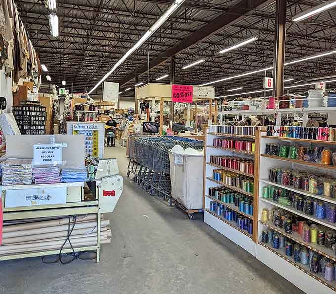 Rows of colorful thread spools and quilt kits stretch into the distance, like a rainbow decided to open a shop.