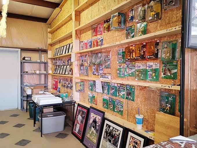 Floor-to-ceiling shelves packed with vintage Starting Lineup figures and framed sports photos, this wall is basically a highlight reel frozen in time.