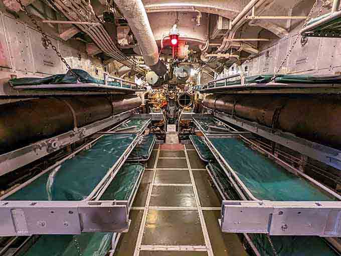 Tight bunks, torpedo tubes, and a red glow overhead: this is where real courage got a few hours of sleep.