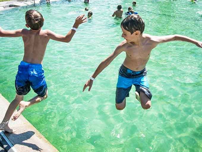 Pure, unscripted joy, two kids launching themselves into crystal-clear water without a single care in the world.