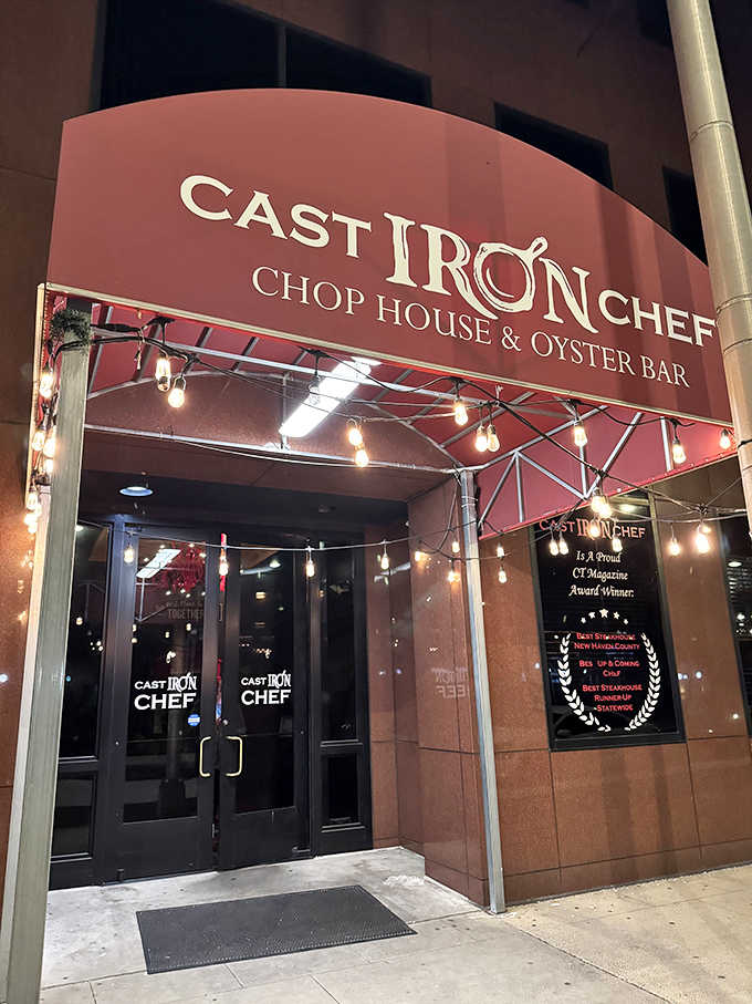 Edison bulbs strung beneath a deep crimson awning make this New Haven entrance feel like opening night, every night.