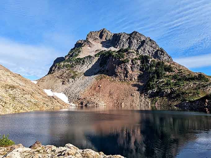 Gothic Basin's dark alpine lake mirrors that rugged peak so perfectly, you'd swear nature hired a professional photographer.