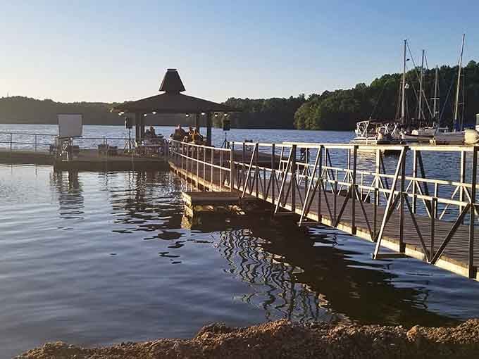 Joe Wheeler's covered pavilion glows warmly over the Tennessee River as sailboats rest quietly in the evening light.