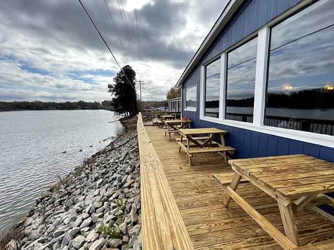 Picnic tables perched on a wooden deck over riprap and water. Lake Bowen Fish Camp keeps it beautifully simple.