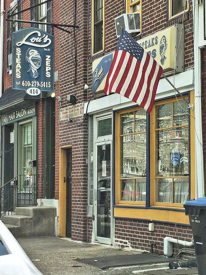 An American flag, a hand-painted sign, and a brick row building: Lou's has neighborhood charm written all over it.