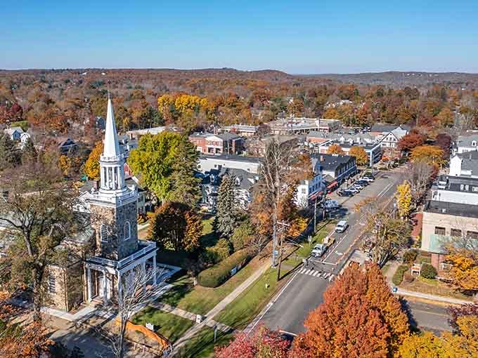 A white church steeple pierces a canopy of fall foliage, making Ridgefield's main street look like a Bob Ross painting came to life.
