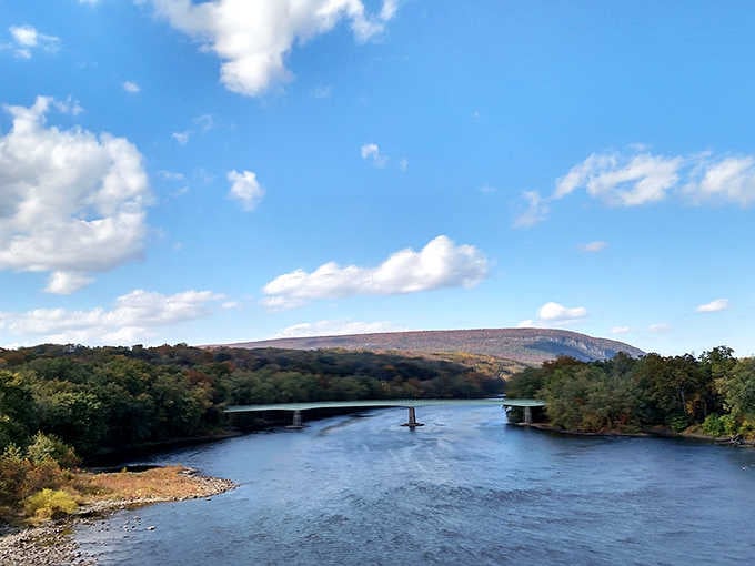 A broad mountain ridge watches over the Delaware River below, wearing its autumn colors like a well-earned medal.