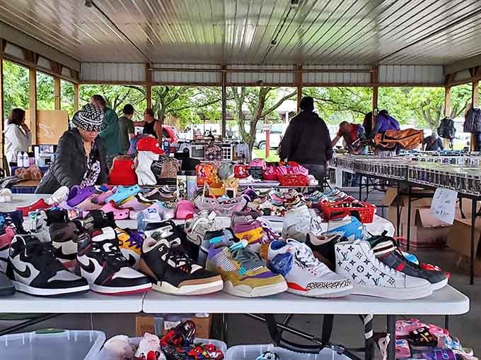 Sneaker culture meets flea market magic, with bold colorful kicks piled high under a covered pavilion.