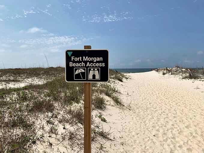 The Fort Morgan Beach Access sign points toward paradise, and those icons promise facilities that actually work, imagine that.