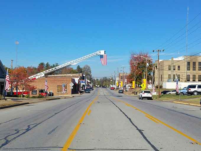 Cue the parade music! An extended ladder truck proudly flies the flag over an absolutely beautiful autumn street scene.