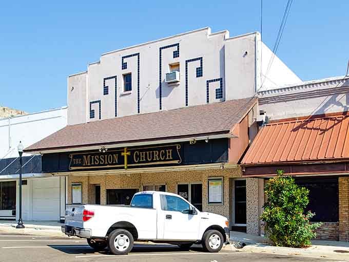 The Mission Church sign commands attention on this sun-drenched Mount Pleasant block, where old storefronts wear their history without apology.