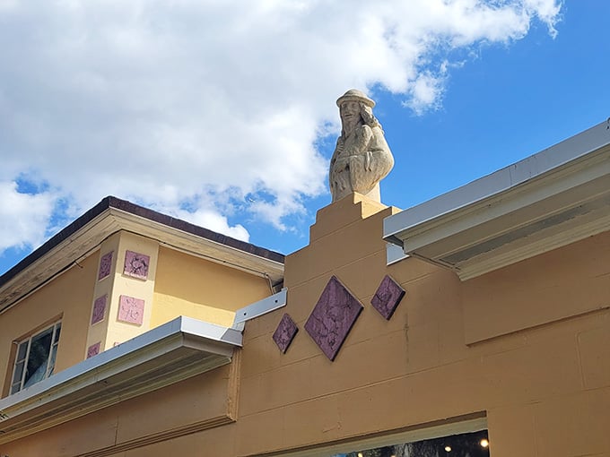 Even the roofline has something to say here. A carved figure perches above it all, quietly judging everyone below.