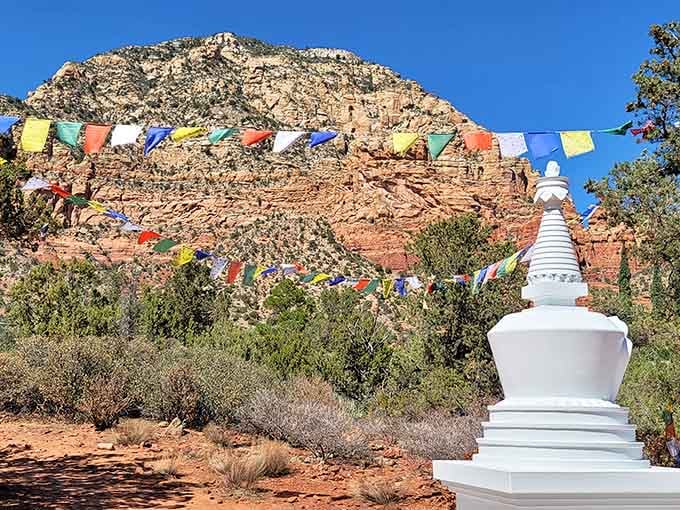 The white stupa stands like a beacon of tranquility with those magnificent red rocks as its backdrop.