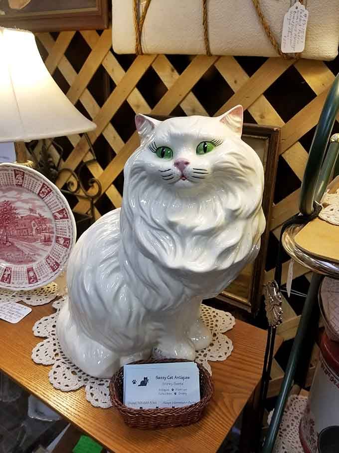 This ceramic cat has seen things. Those green eyes are judging every item you almost bought and put back.