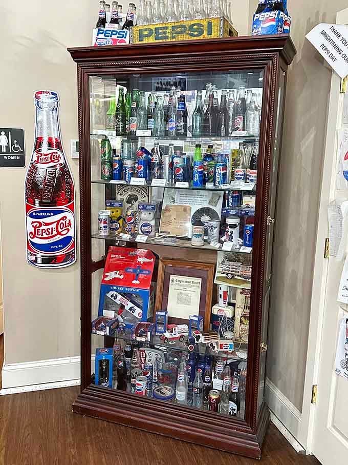A tall glass cabinet packed with vintage Pepsi bottles, each one a tiny time capsule from a different era.