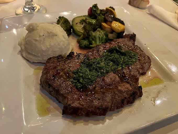 The NY strip arrives with that perfect char, proving sometimes the classics become classics for good reason.