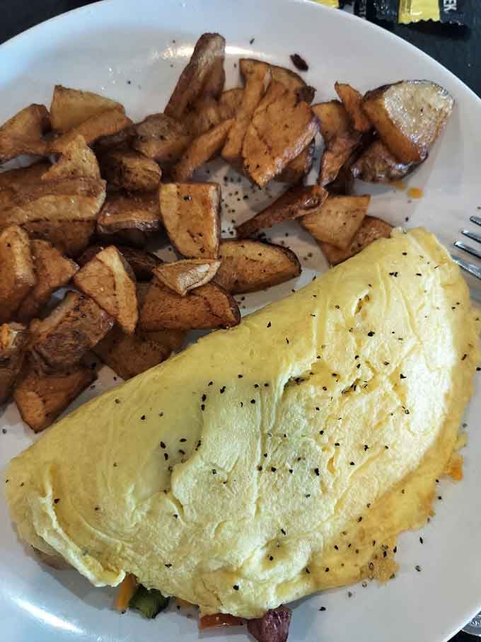 Fluffy, golden, and loaded with good things inside, this omelet paired with home fries is pure mountain morning magic.