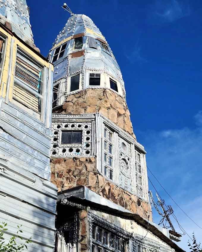 One tower up close reveals layers of stone, salvaged windows, and aluminum that somehow all make perfect sense together.