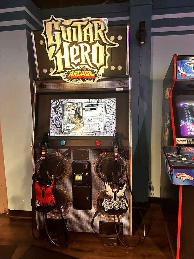 The Guitar Hero arcade cabinet is here, two guitars ready, waiting for someone brave enough to embarrass themselves publicly.