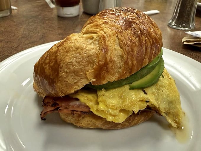 Fluffy scrambled eggs on a buttery croissant with pickles, because someone finally understood what breakfast should be.