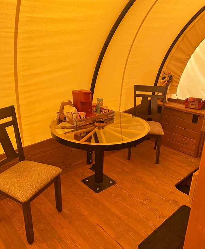 A wagon wheel table inside a covered wagon. Someone out here is absolutely committed to the theme.