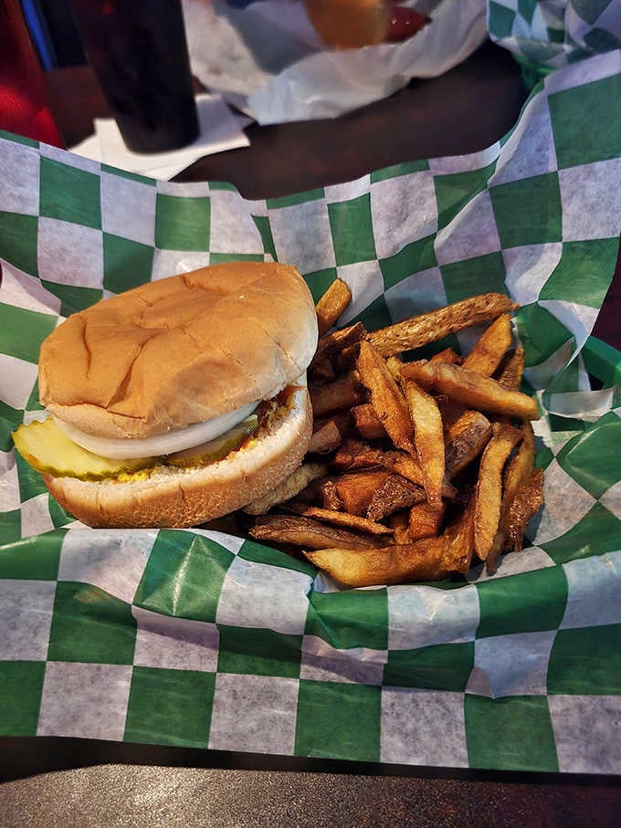 A fresh-never-frozen burger and a mountain of hand-cut fries served in a green checkered basket. Pure, simple perfection.