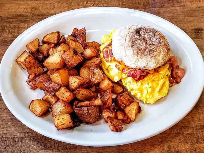 Golden, crispy home fries beside a stuffed breakfast sandwich, proof that mornings deserve this much respect.