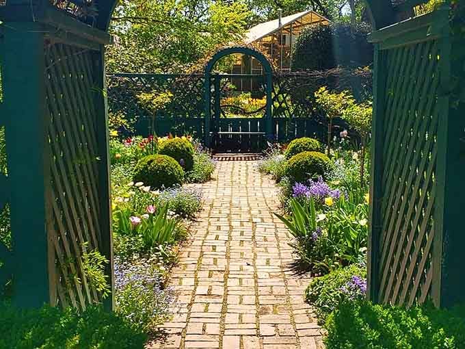 A brick pathway lined with tulips and blooms that would make any English garden jealous.