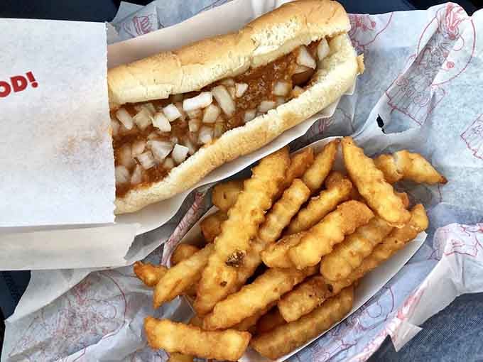 A chili coney dog with diced onions and crinkle fries, this is comfort food doing its very best work.