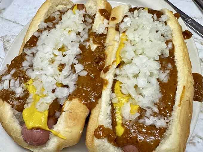 Two coney dogs loaded with chili sauce, yellow mustard, and diced onions, proof that perfection doesn't need to be complicated.