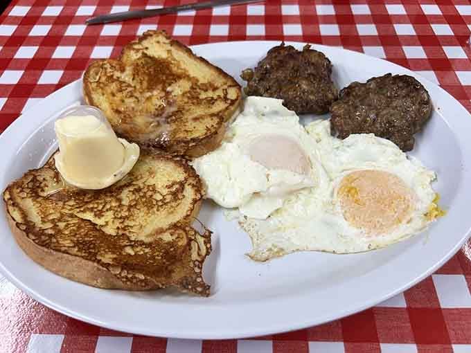 French toast, eggs, and sausage arranged on a plate like they're posing for their high school yearbook photo.