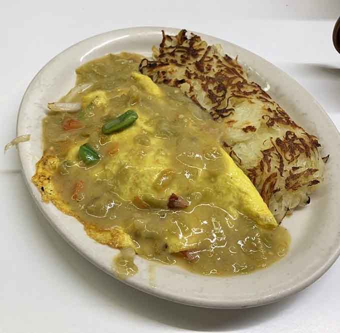 Golden omelet, crispy hashbrowns, green chili pooling over everything like a warm Colorado welcome you didn't know you needed.