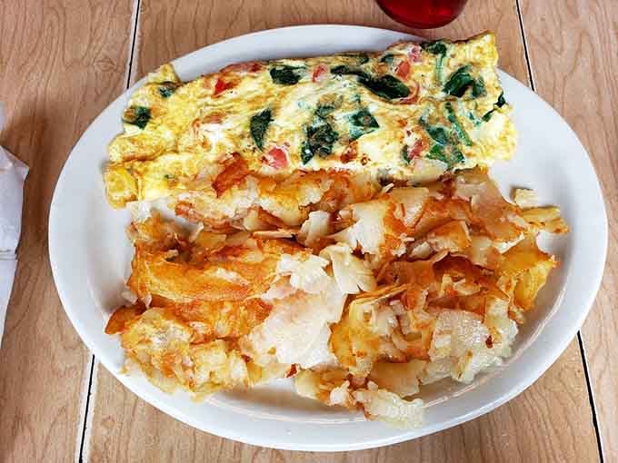 The Greek omelet arrives like a Mediterranean sunrise on your plate, golden and full of promise for the day ahead.