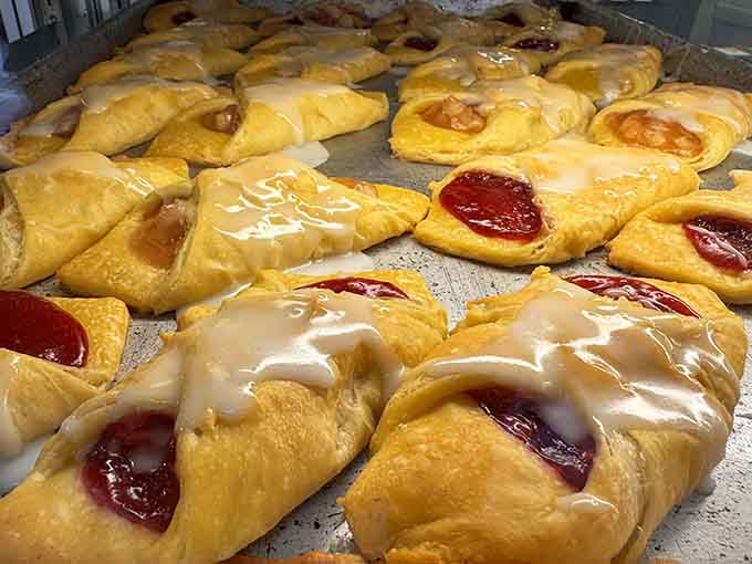 Fresh-baked turnovers lined up in rows, glazed and golden, like little pastry gifts nobody asked for but everyone needs.