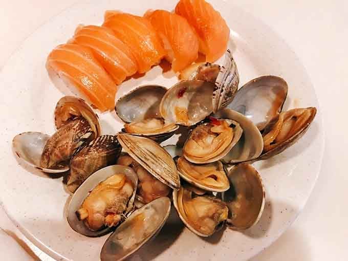 Salmon sushi and clams on one plate, because why choose when you can have everything?
