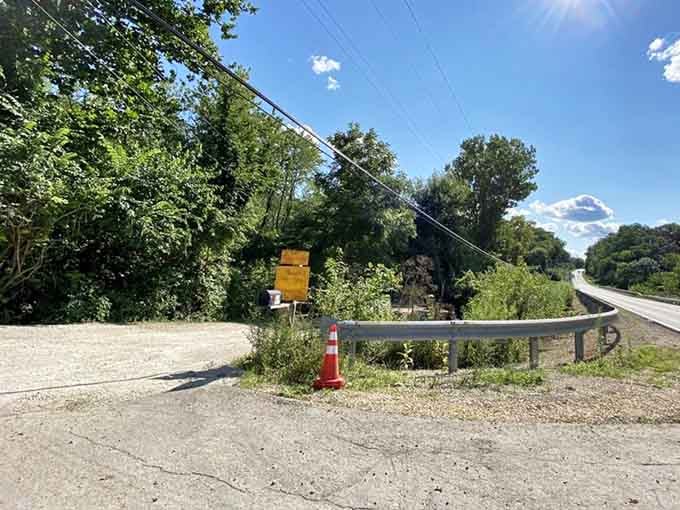 A humble roadside sign and an orange cone mark the entrance, proof that great adventures don't need fancy billboards.