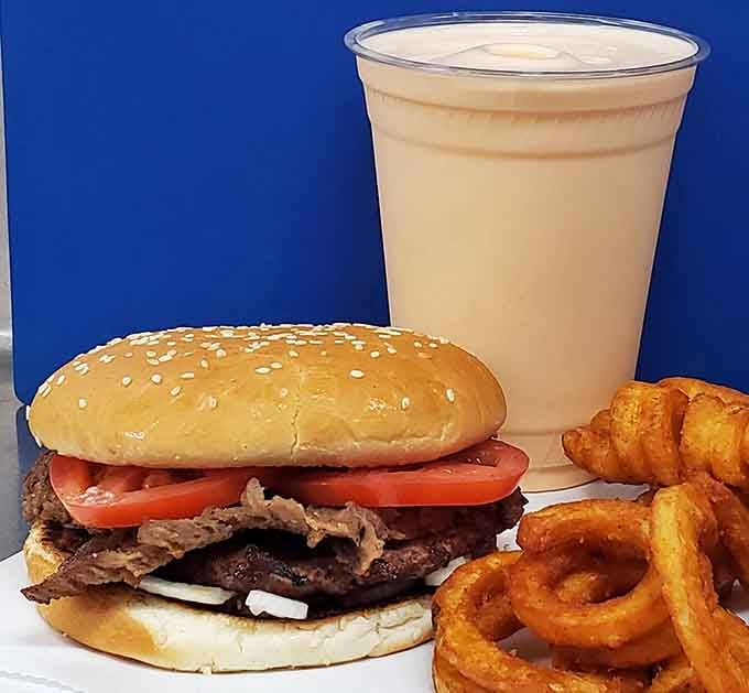 A loaded burger, curly fries, and a creamy shake walk into a frame. Nobody leaves disappointed.