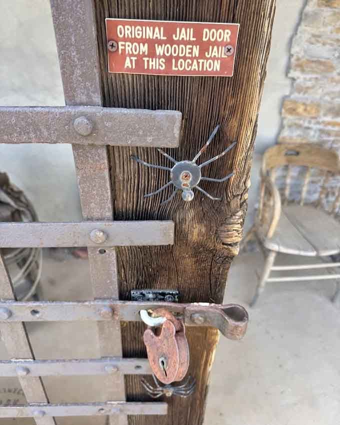 The original wooden jail door survived here, proving that good craftsmanship outlasts even the toughest customers it contained.