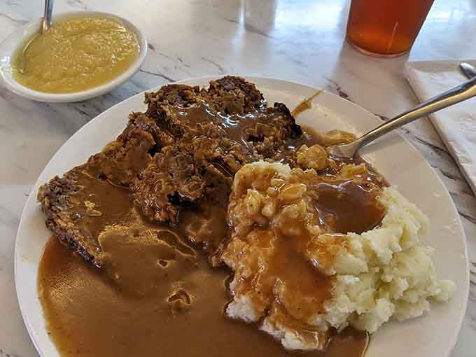 Meatloaf and mashed potatoes drowning in homemade gravy, this plate is basically a warm hug you can eat.