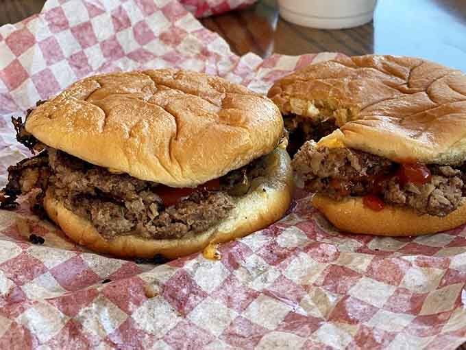 Two smashed burgers sitting on checkered paper, looking like everything right with the world wrapped in a bun.