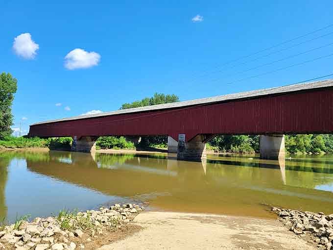 Four hundred feet of red-painted history stretching across the river, perfectly mirrored in the water below.